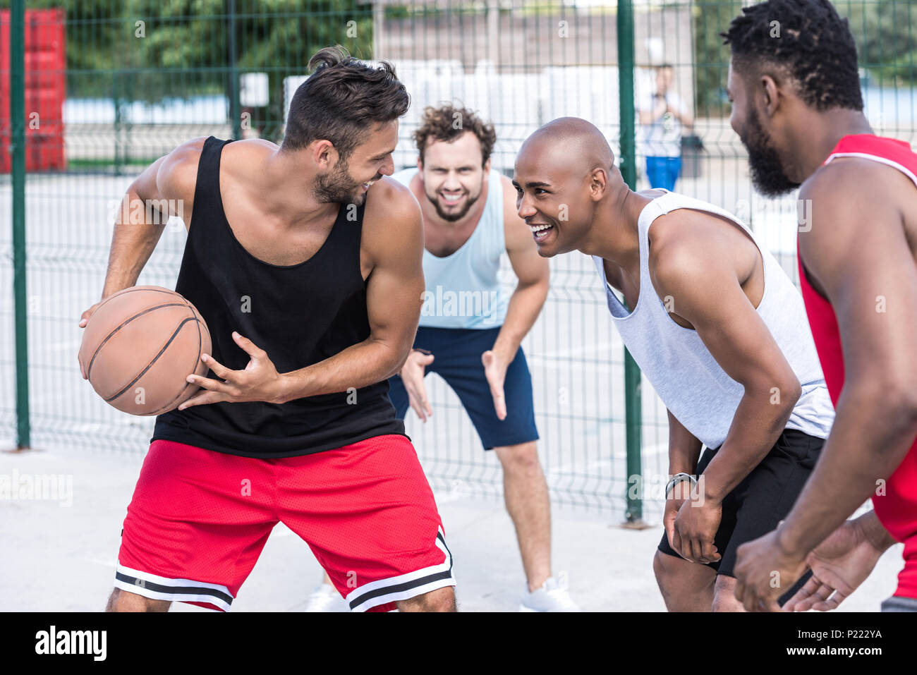 multiethnic group of basketball players playing basketball on court ...