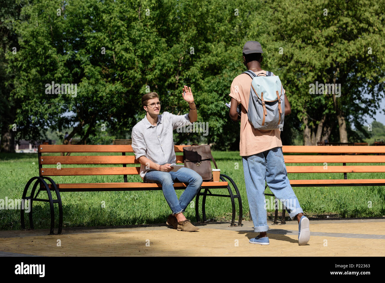 Handsome young man waving to his friends Stock Photo - Alamy