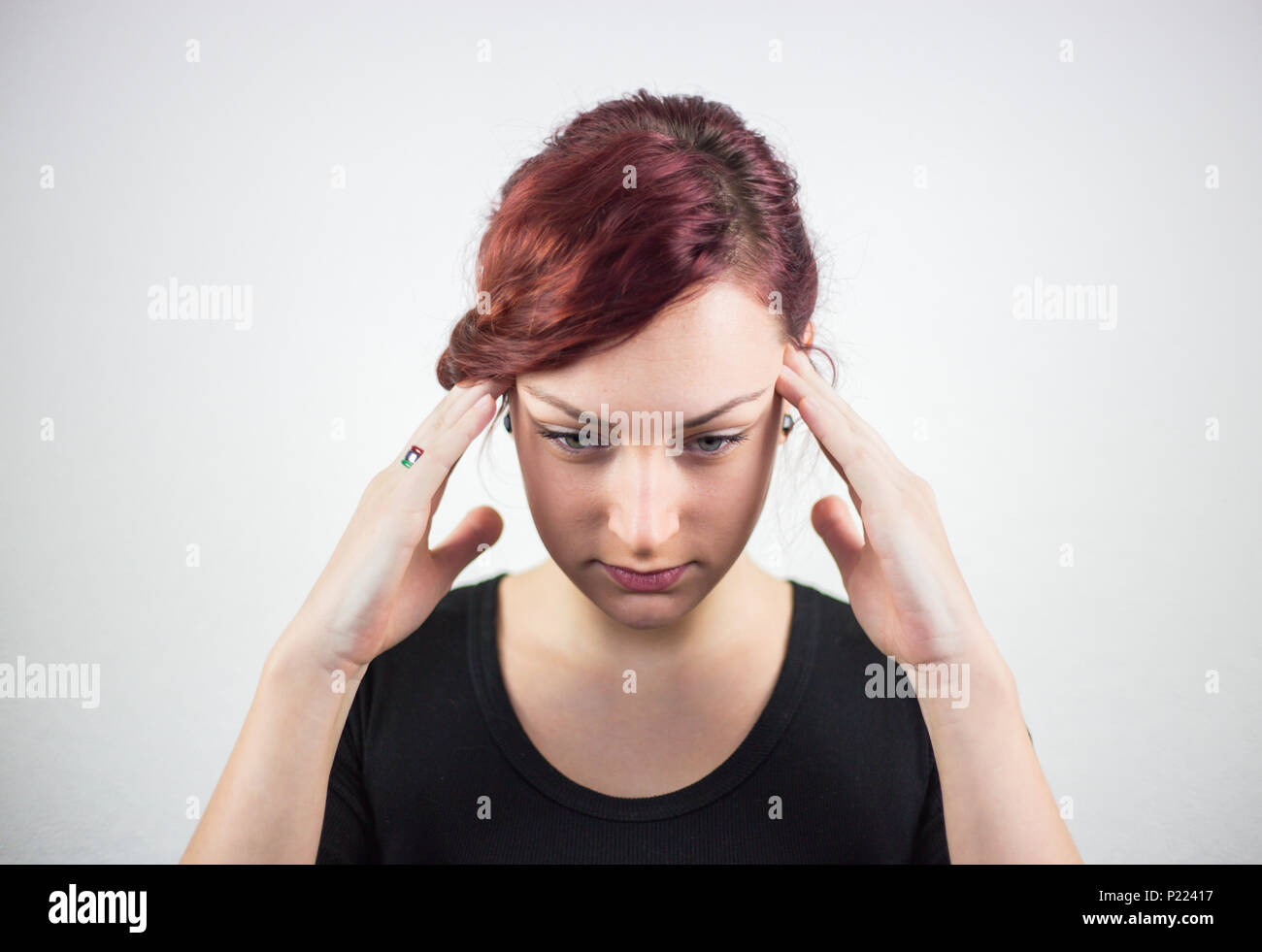 A young girl with facial expression, and hands shows that the pain is ...