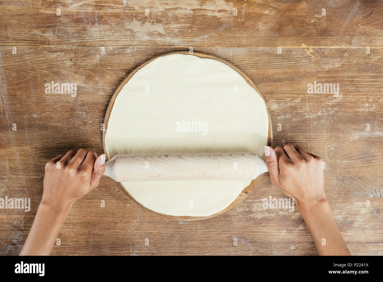 Top view of hands rolling pizza dough with pin on table Stock Photo - Alamy