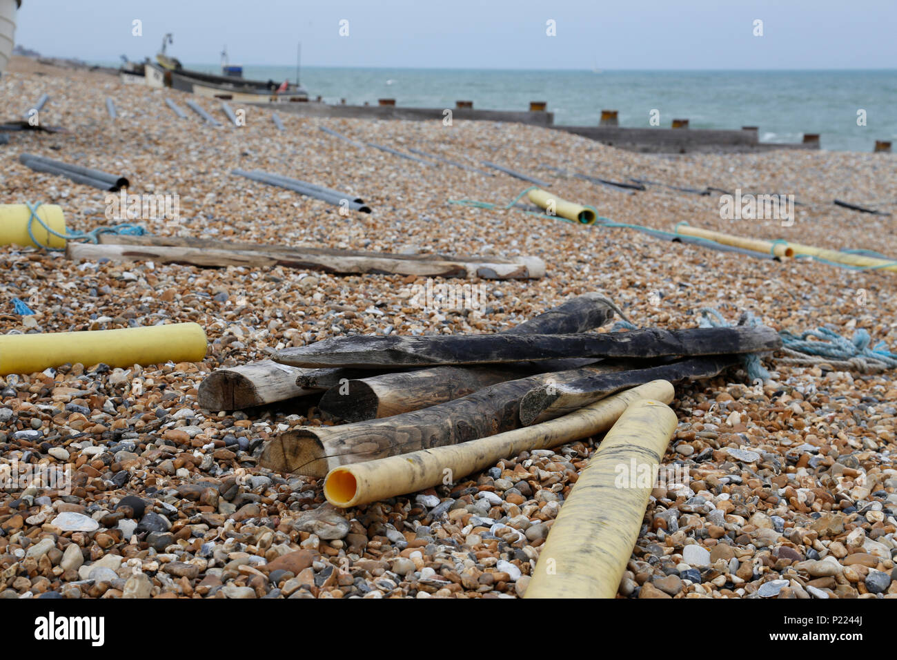 Old pipes and wood on pebble beach Stock Photo - Alamy