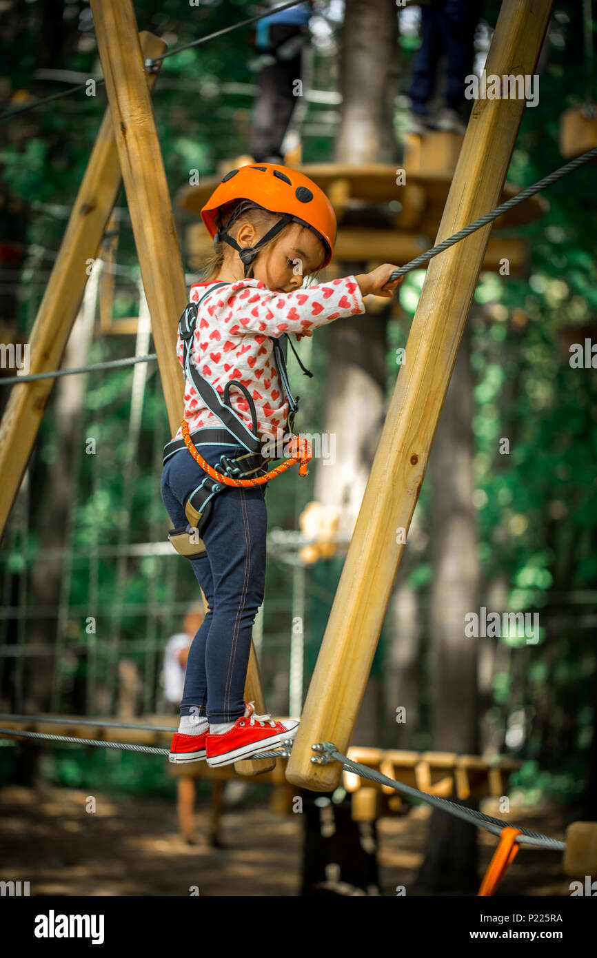 sports happy kid climbs through the ropes, the beautiful girl in the ...