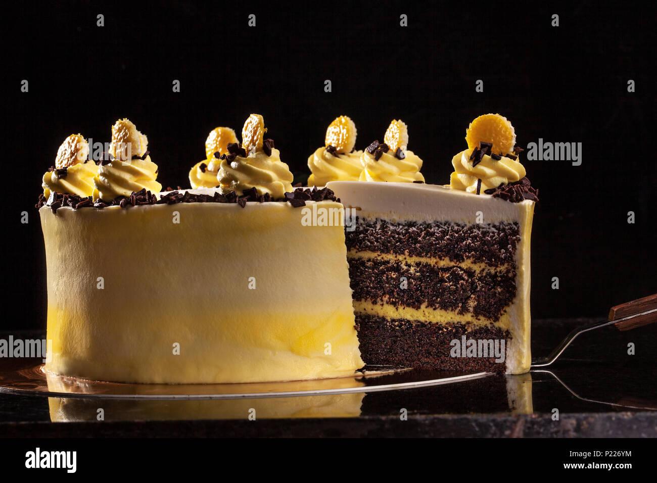 Round yellow birthday cake. Decorative cream decorations on the cake ...