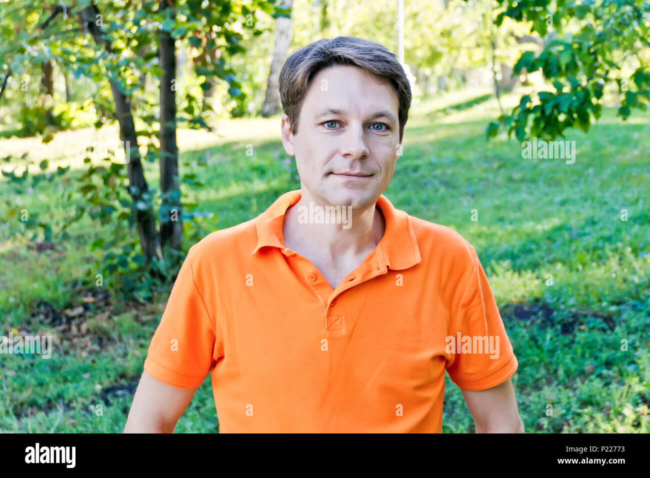 Horizontal portrait of man in orange on green background Stock Photo ...