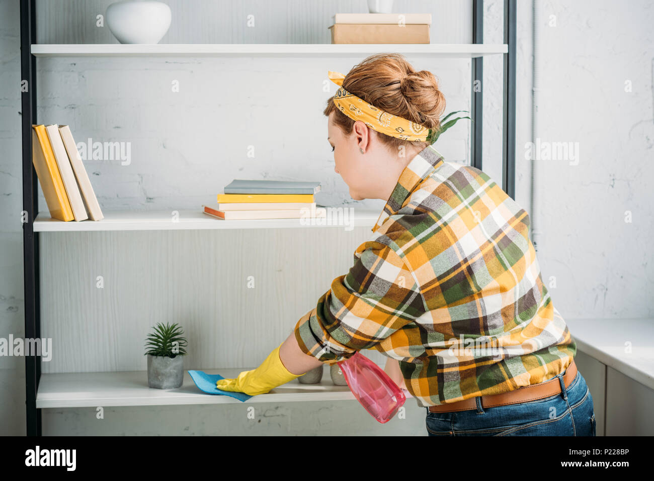 side view of beautiful woman dusting shelves at home Stock Photo - Alamy