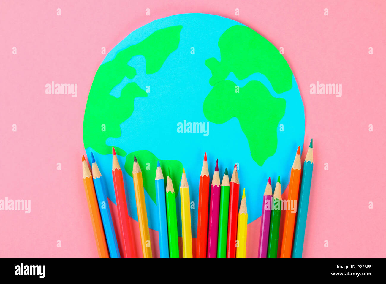 World art. Planet Earth and pencils, brushes on a pastel pink ...