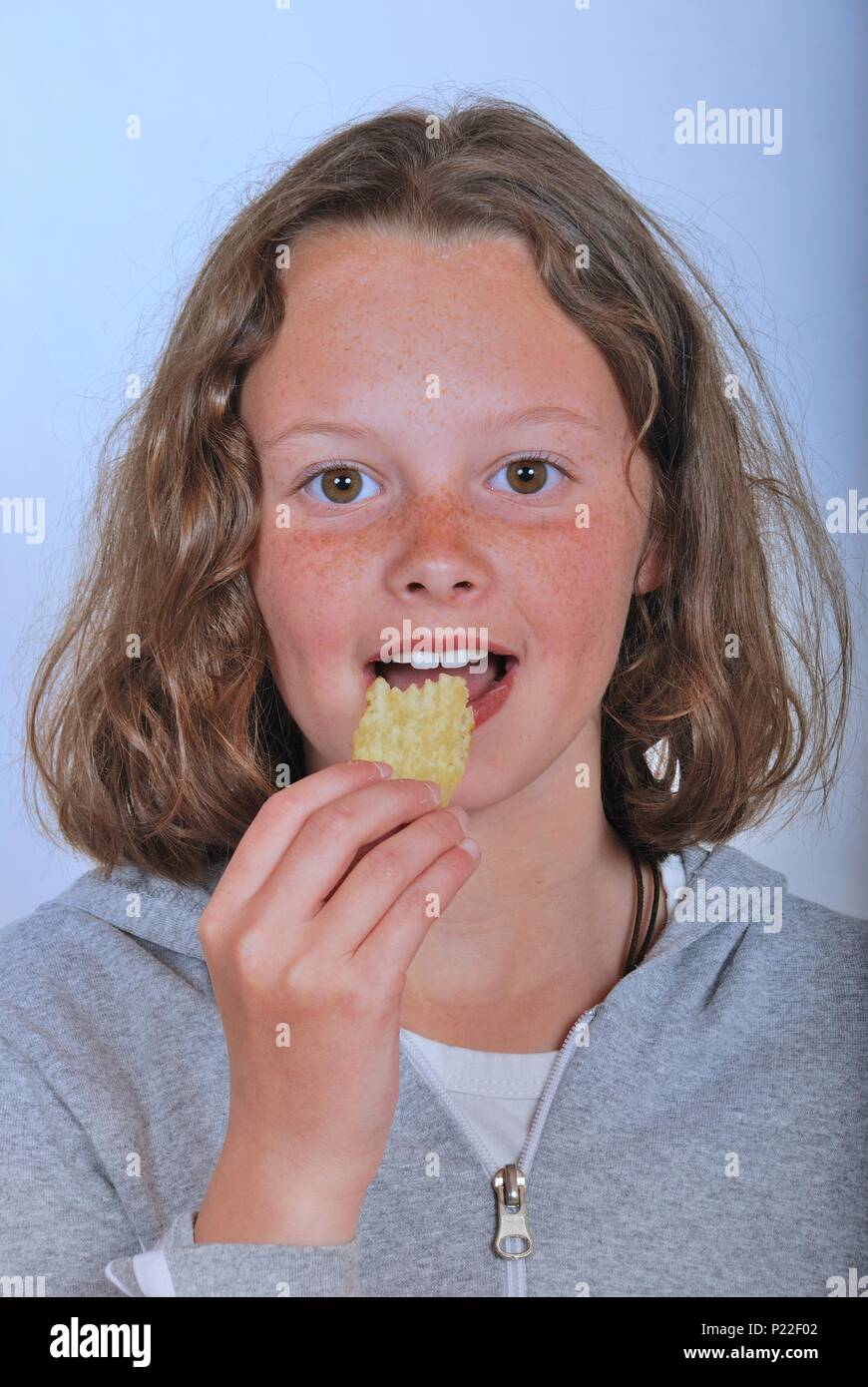 Girl eating chip Stock Photo - Alamy