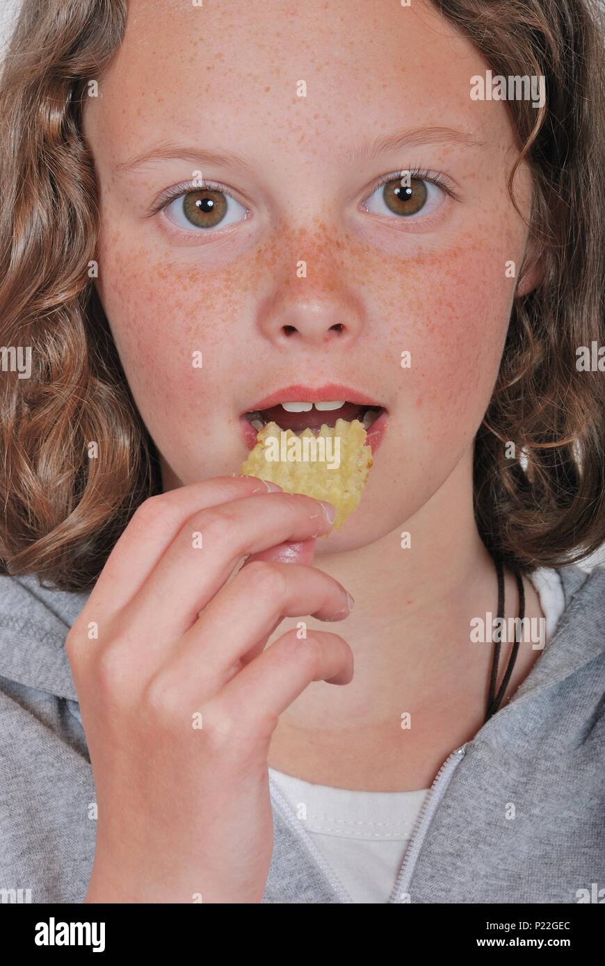 Girl eating chip Stock Photo - Alamy
