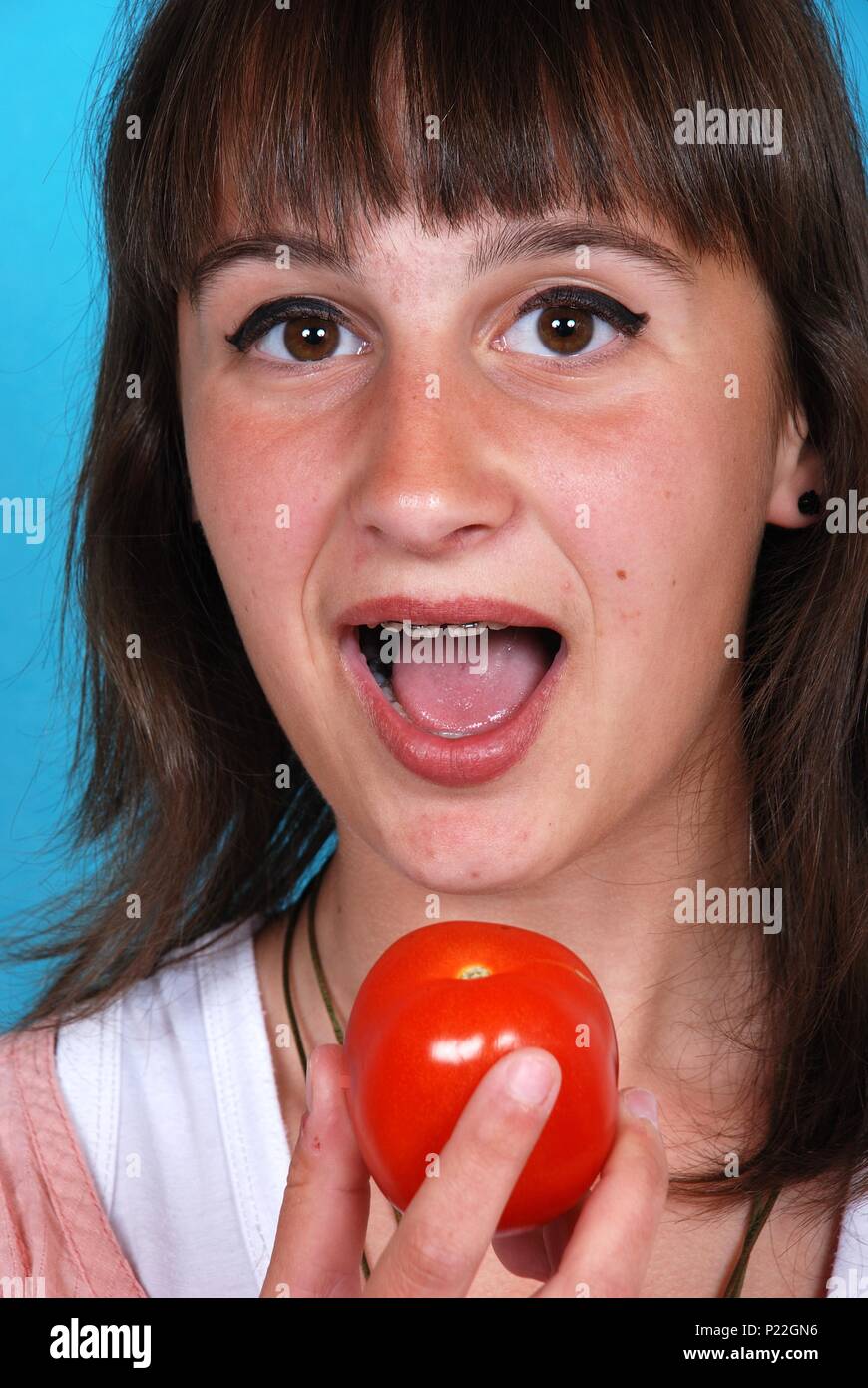 Girl eating a tomato Stock Photo - Alamy