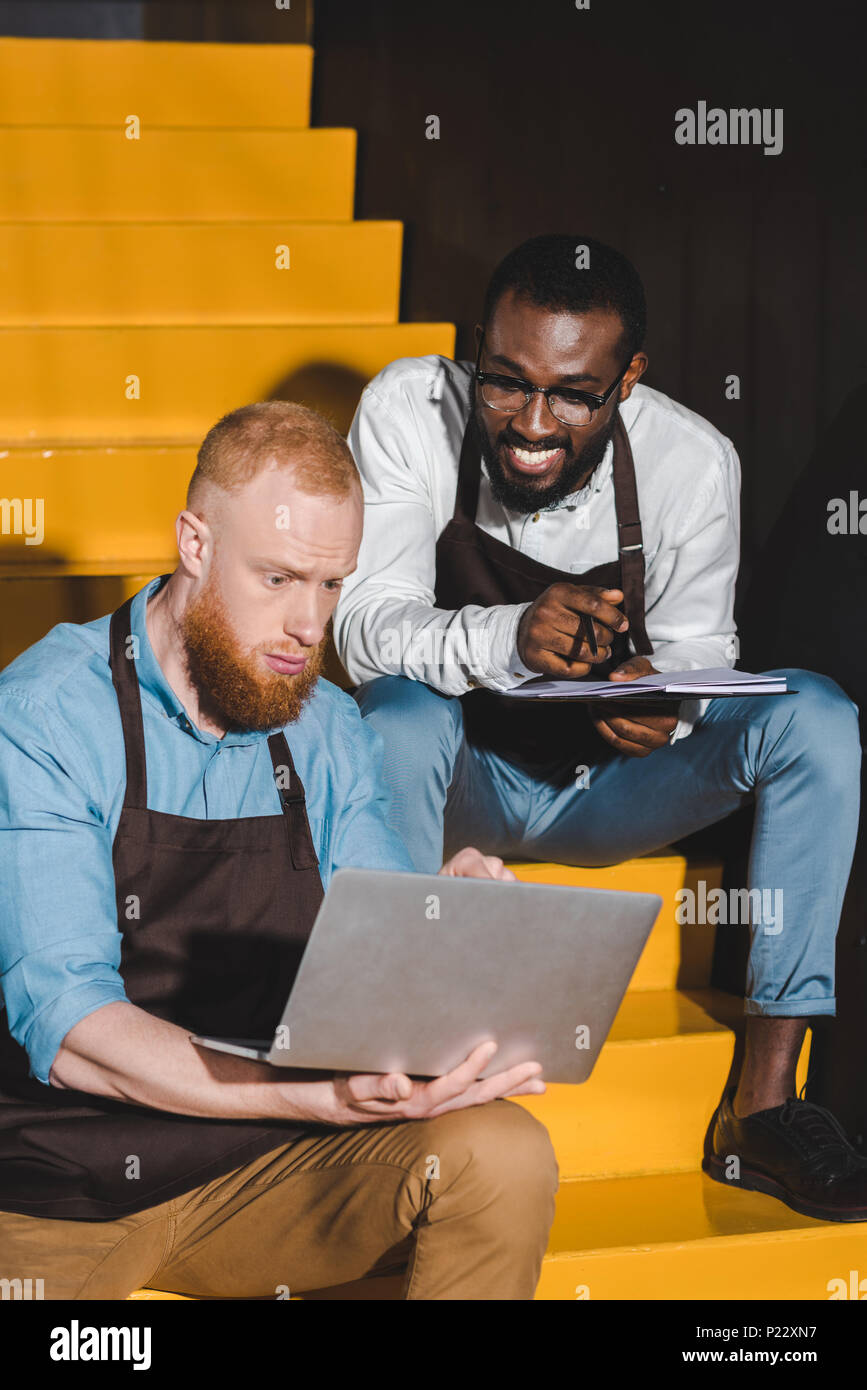 young male owners of coffee shop with textbook and laptop Stock Photo ...