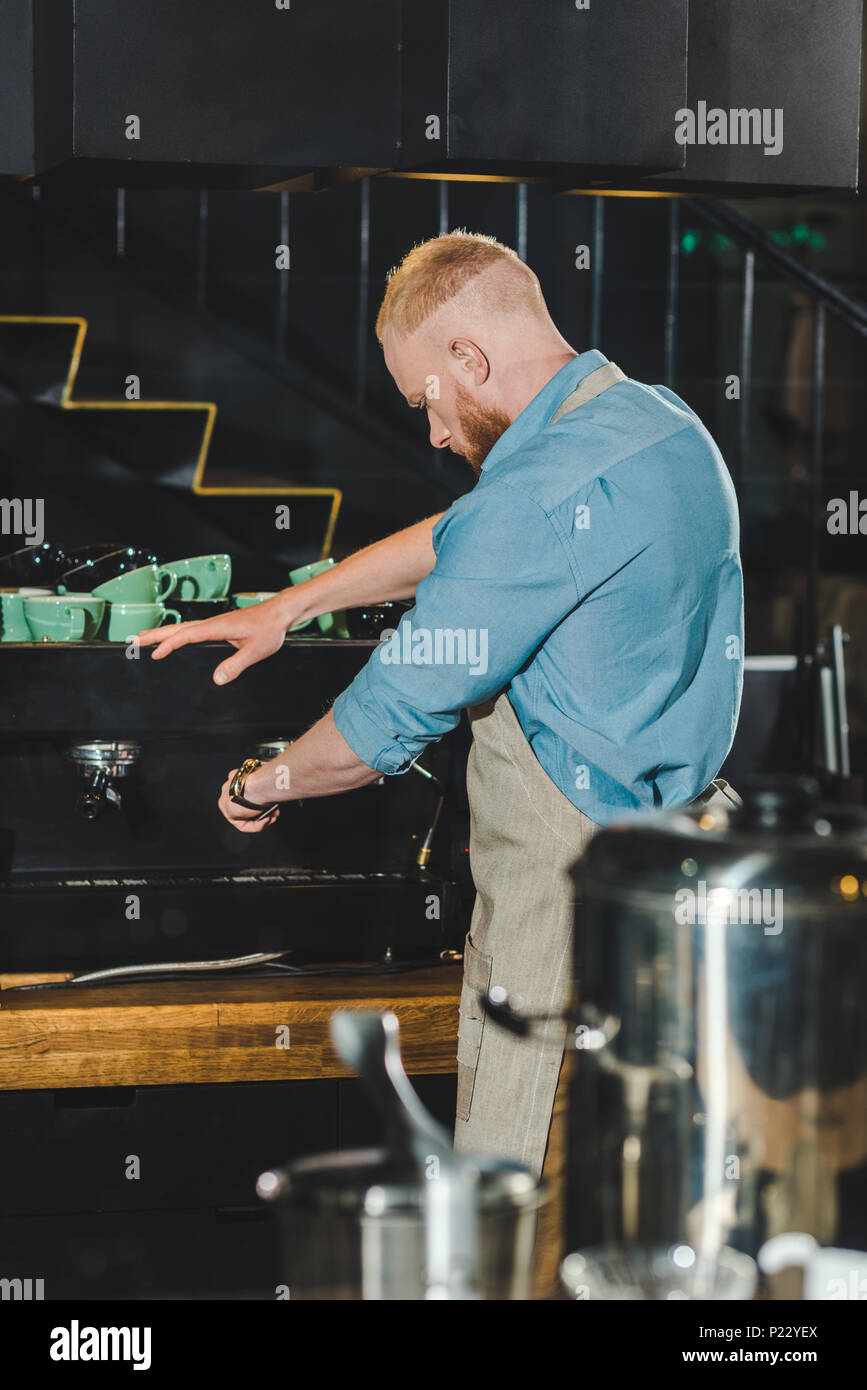 rear view of young male barista using coffee machine Stock Photo - Alamy