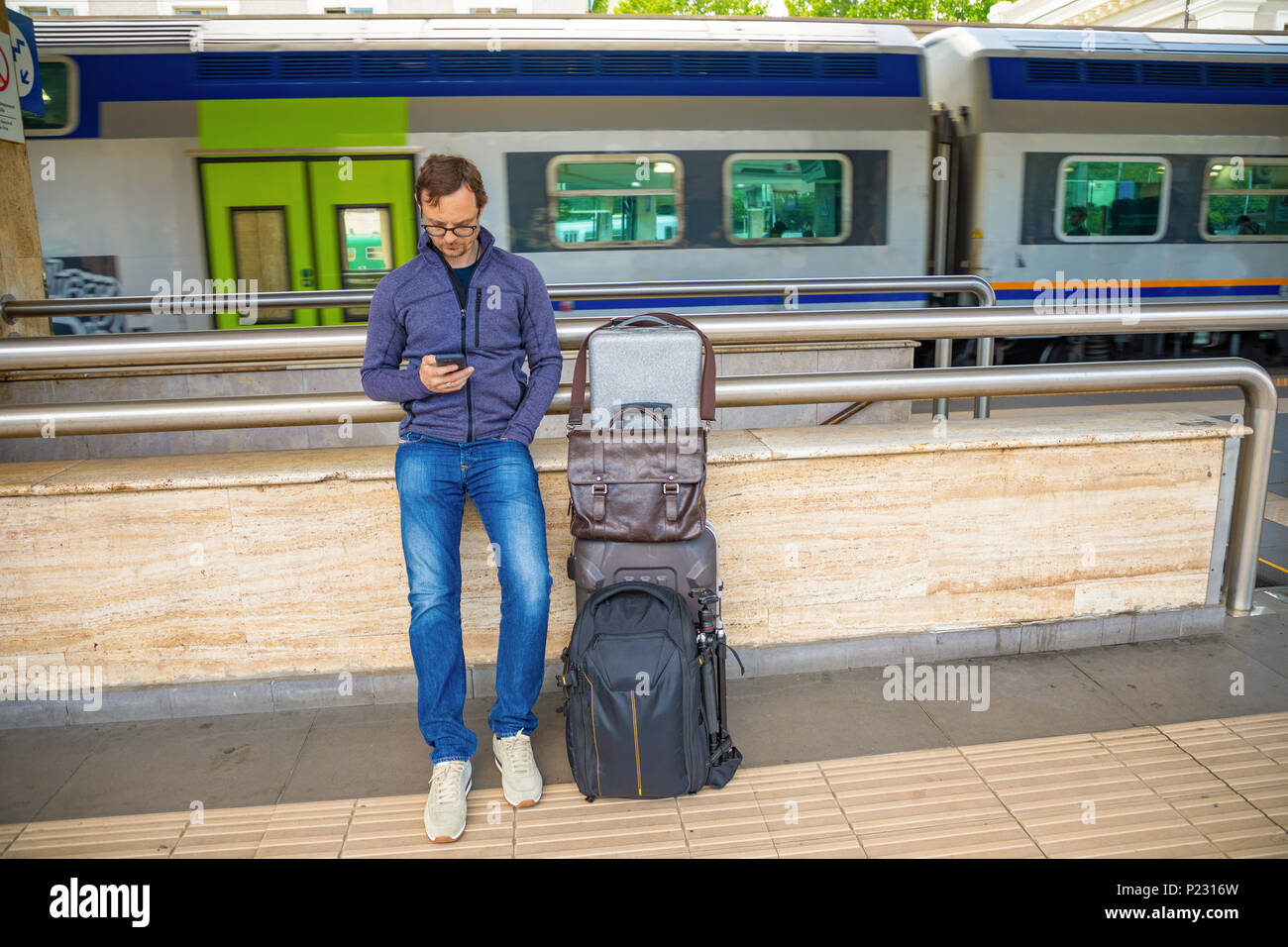 Man waiting train on platform of railway station in Rimini in Italy ...
