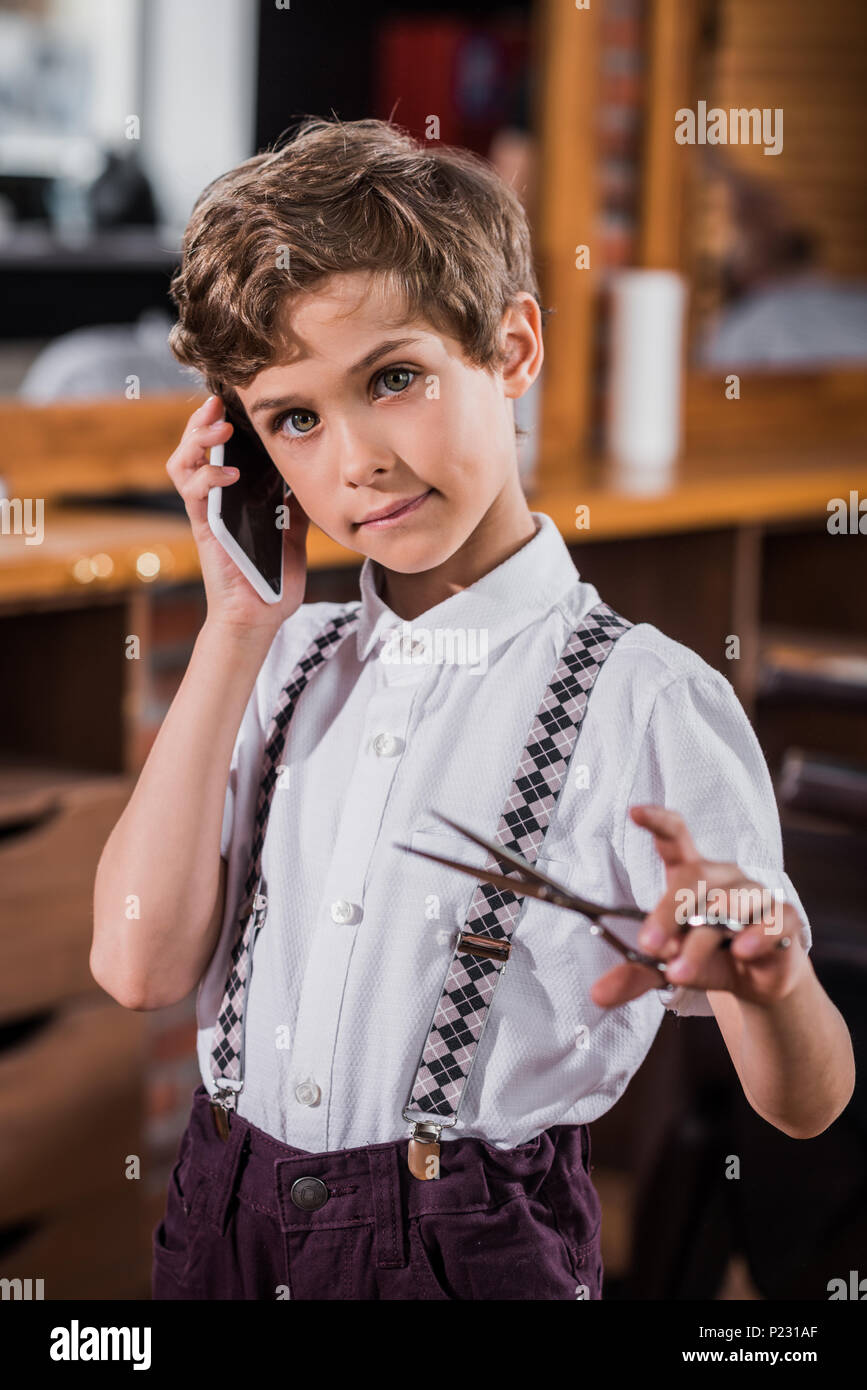 little kid with scissors talking by phone at barbershop Stock Photo - Alamy