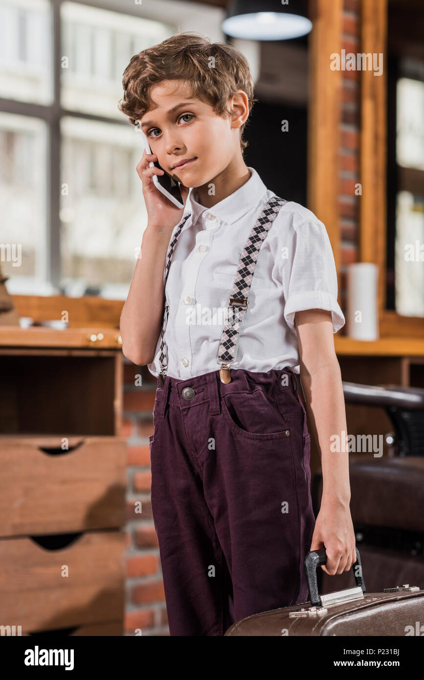 adorable little kid talking by phone at barbershop Stock Photo - Alamy