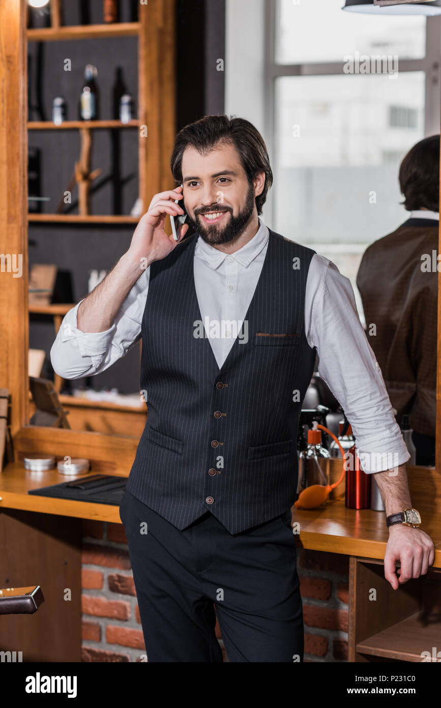 handsome young barber talking by phone at workplace Stock Photo - Alamy