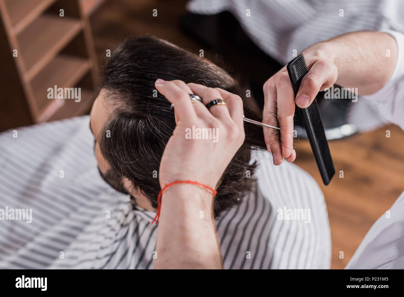 high angle view of barber cutting hair of customer with scissors Stock ...