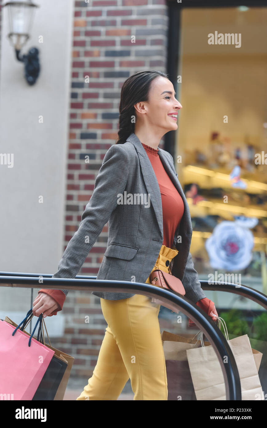 side view of attractive woman walking with shopping bags Stock Photo ...
