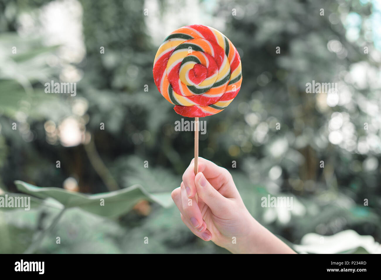 Hand holding lollipop hi-res stock photography and images - Alamy