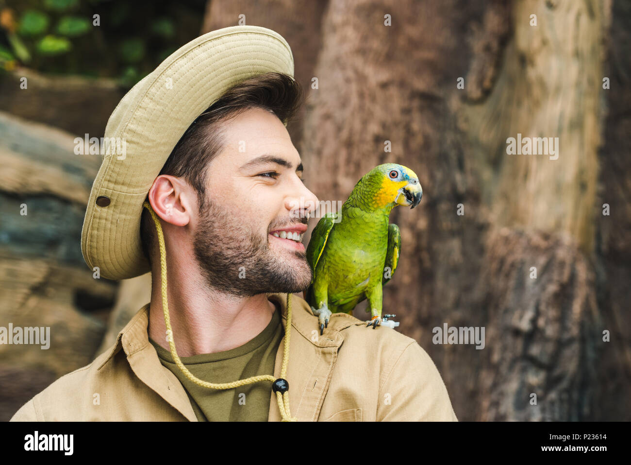 handsome young man with parrot on shoulder in jungle Stock Photo - Alamy