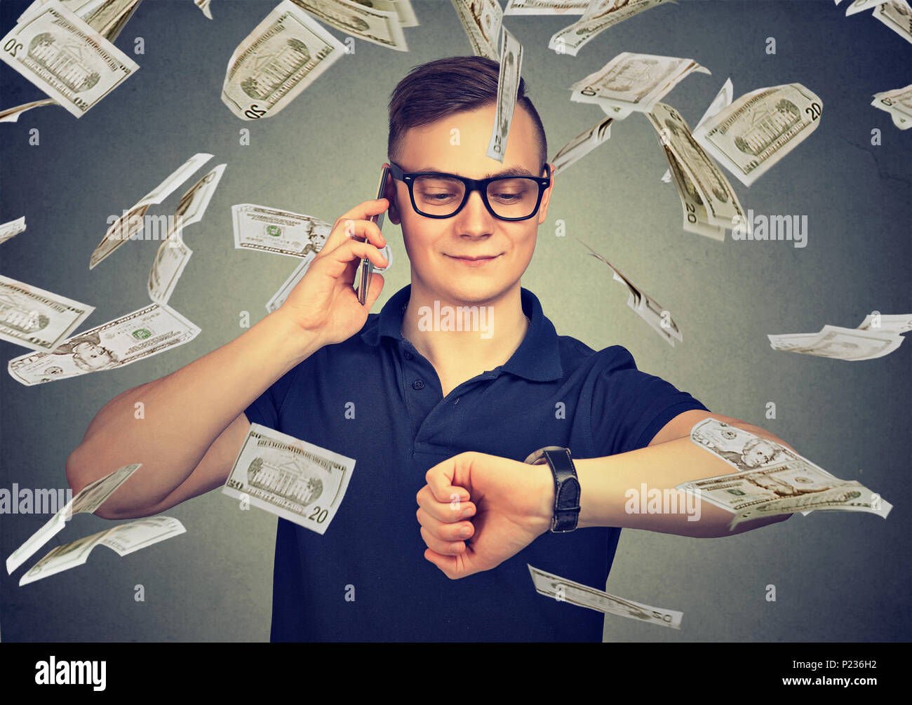 Busy businessman looking at wrist watch, talking on mobile phone under ...