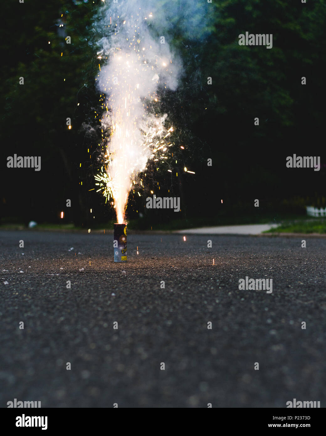 Small novelty cake fireworks exploding on a street at night Stock Photo ...