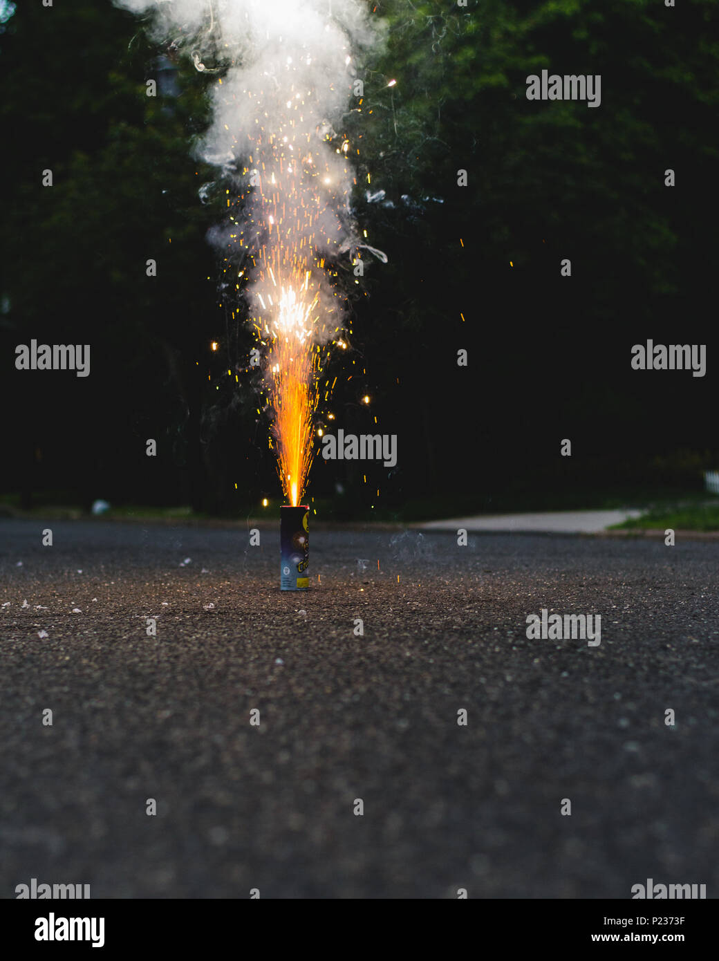 Small novelty cake fireworks exploding on a street at night Stock Photo ...