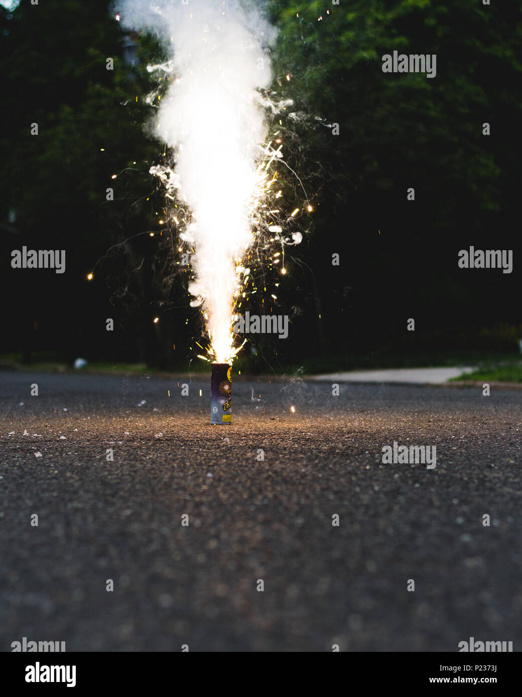 Small novelty cake fireworks exploding on a street at night Stock Photo ...