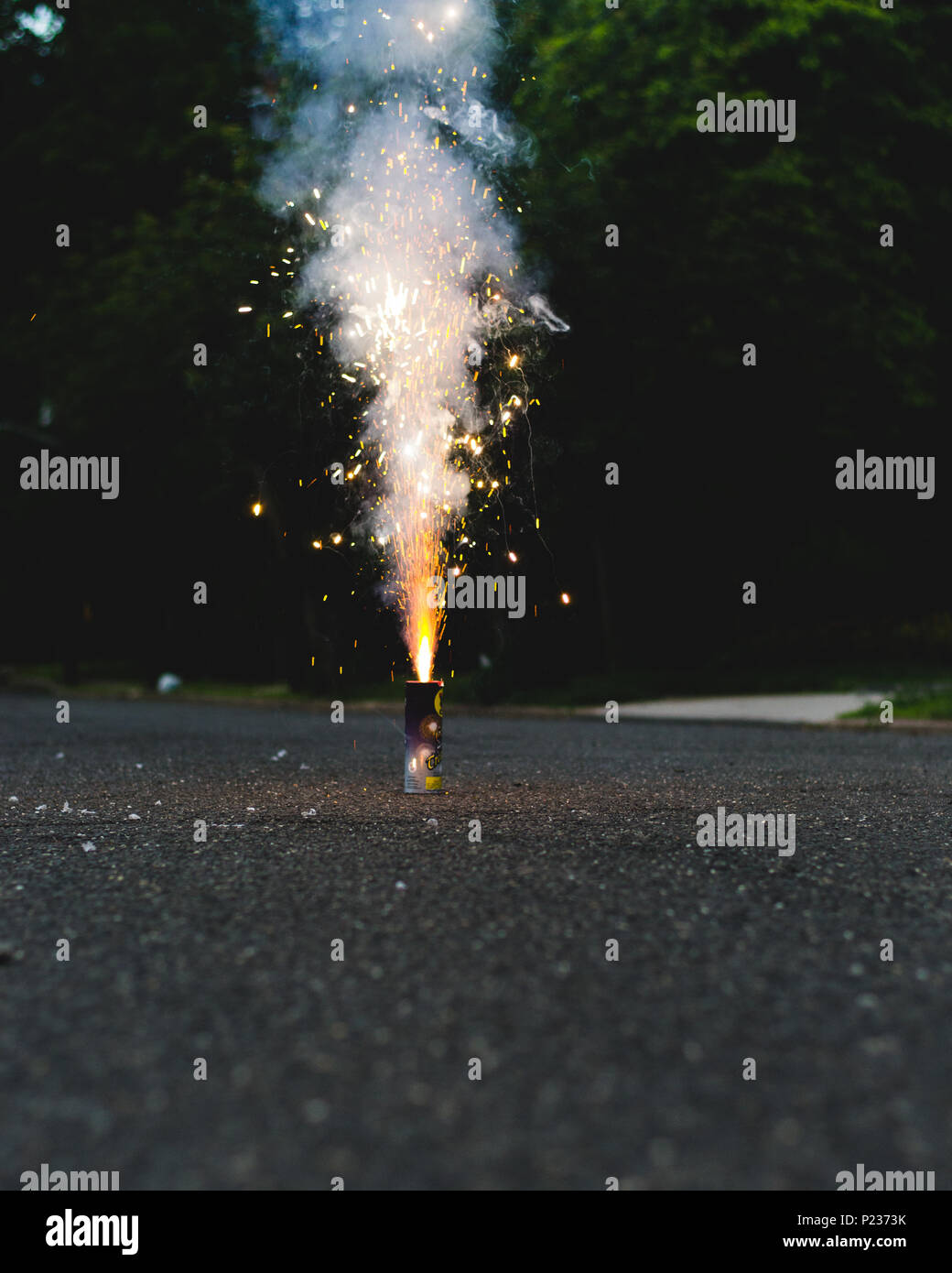 Small novelty cake fireworks exploding on a street at night Stock Photo ...