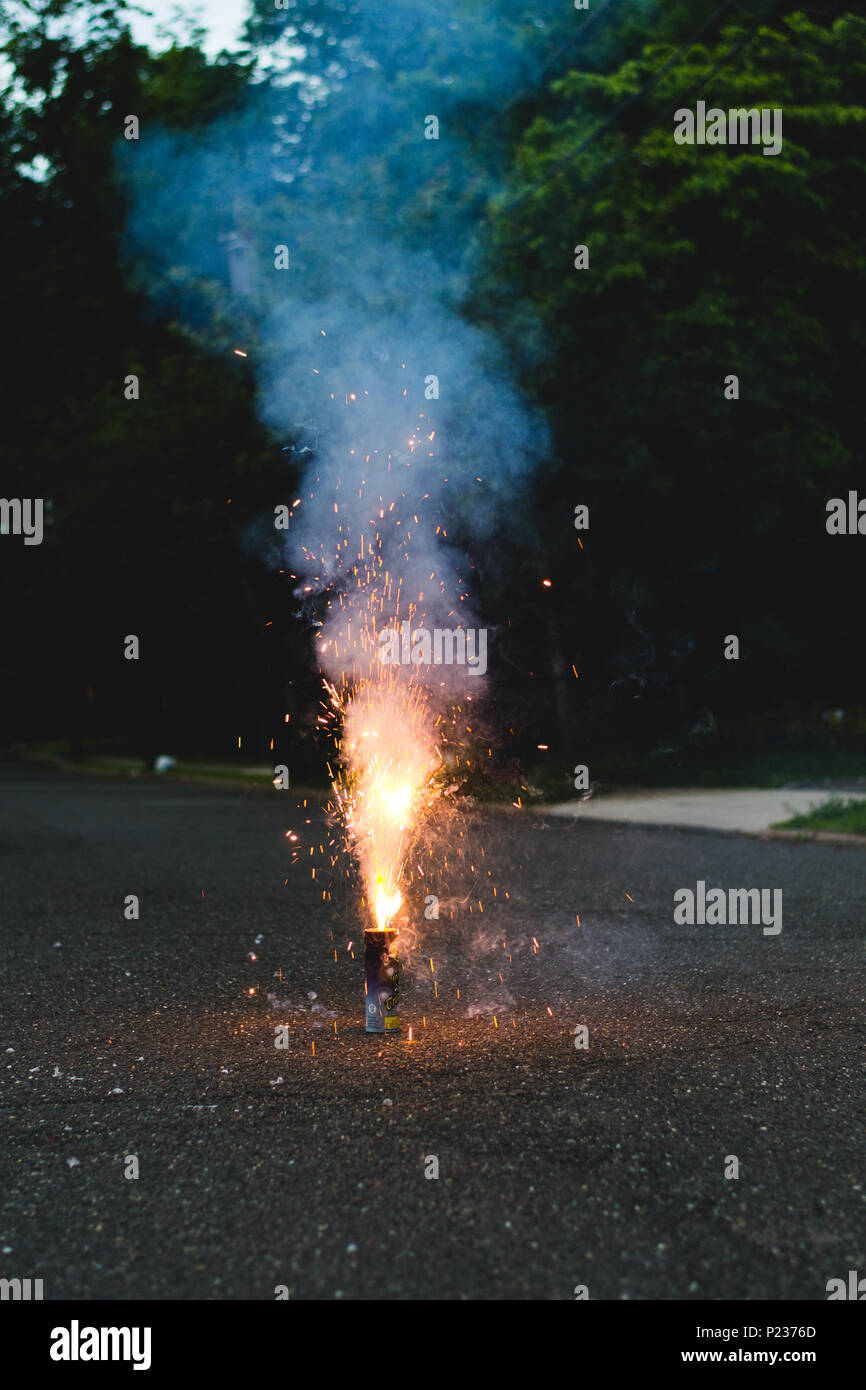 Small novelty cake fireworks exploding on a street at night Stock Photo ...