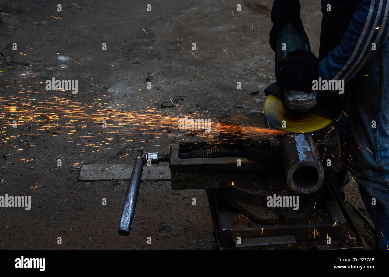 Metal work. Man grinds a steel piece with an angle grinder Stock Photo ...