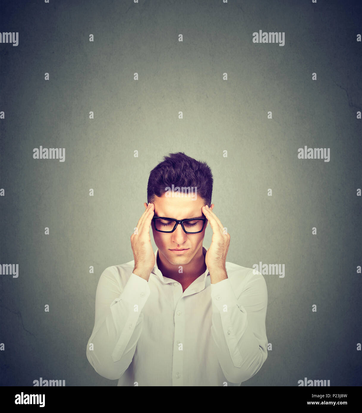 Stressed man thinking intensely concentrating isolated on gray ...