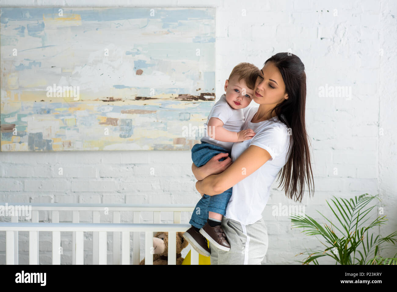 young mother holding cute baby boy in hands at home Stock Photo - Alamy