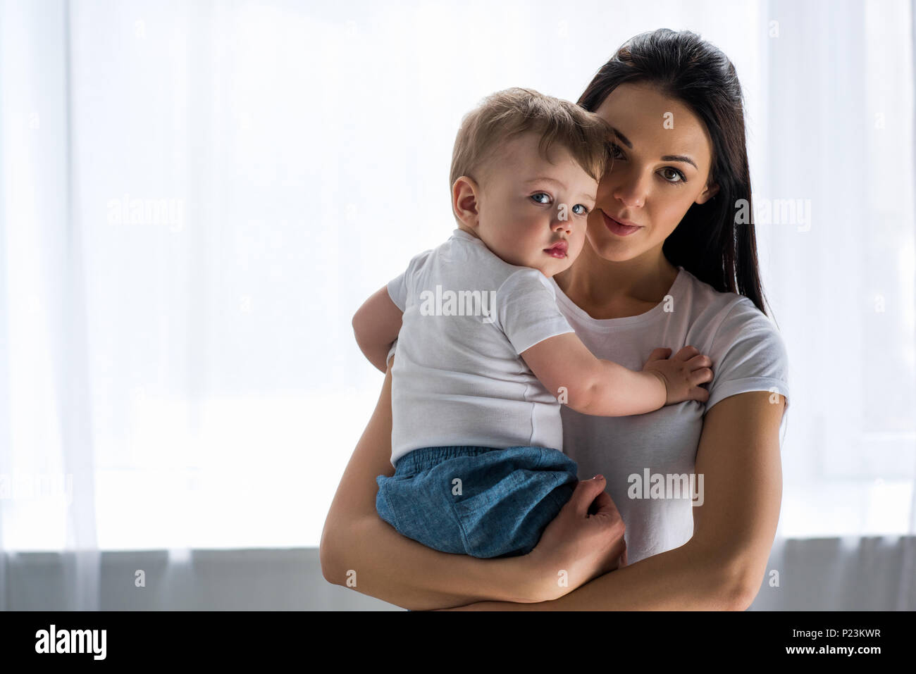 portrait of young mother holding cute baby in hands at home Stock Photo - Alamy
