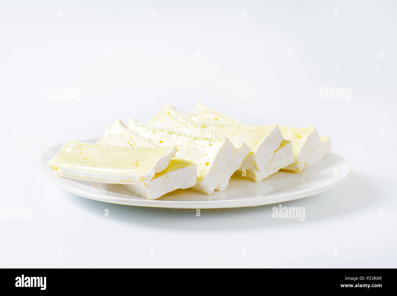 plate of sliced soft cheese with white rind on white background Stock ...