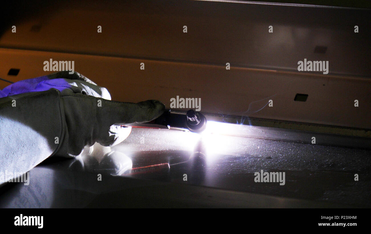 The employee performs welding in the gas shield of construction ...