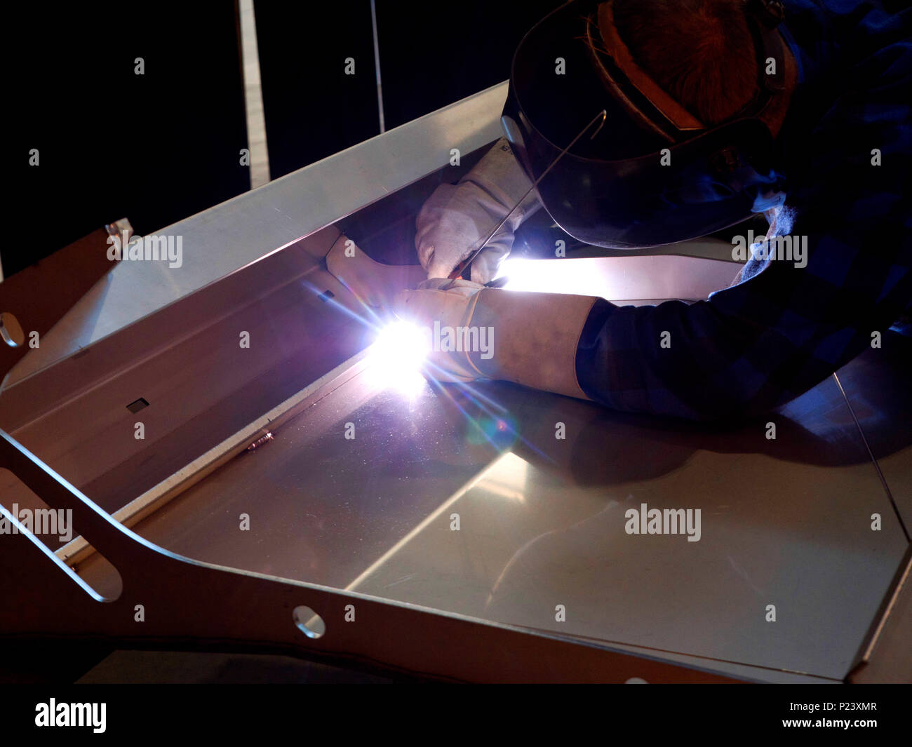 The employee performs welding in the gas shield of construction ...