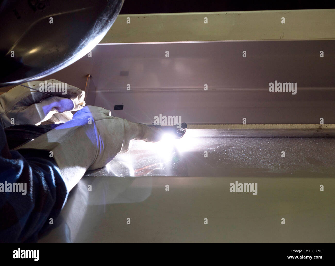 The employee performs welding in the gas shield of construction ...