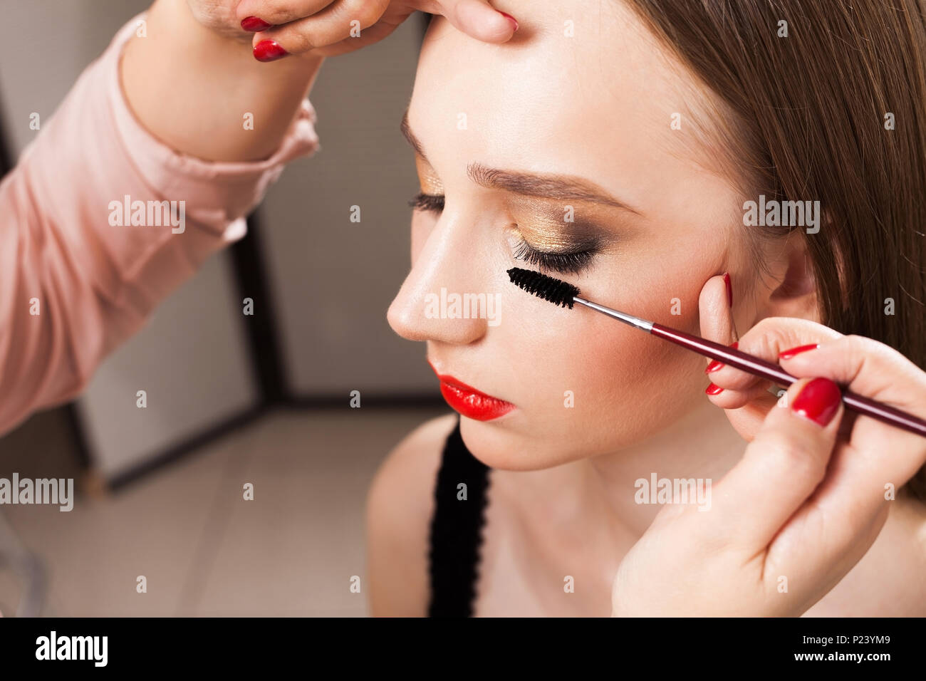 makeup artist applying mascara on a model close up Stock Photo - Alamy