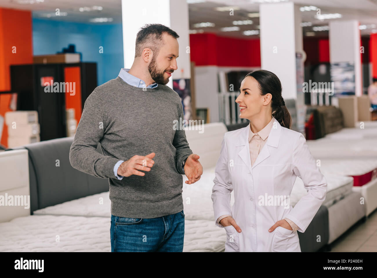 selective focus of male customer and shop assistant in white coat in ...