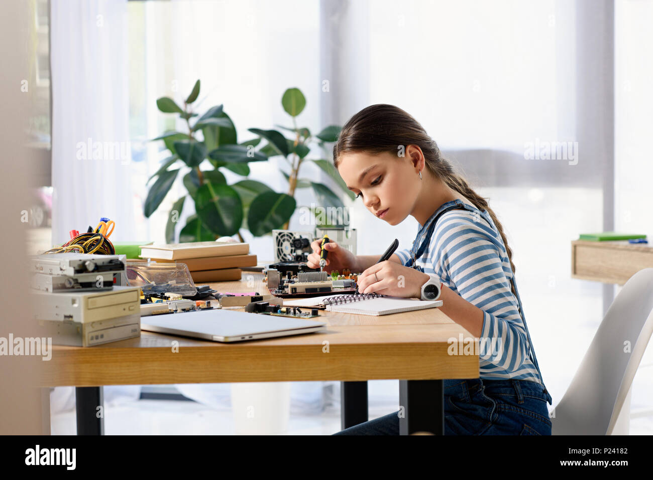 side view of adorable preteen child fixing computer motherboard and ...