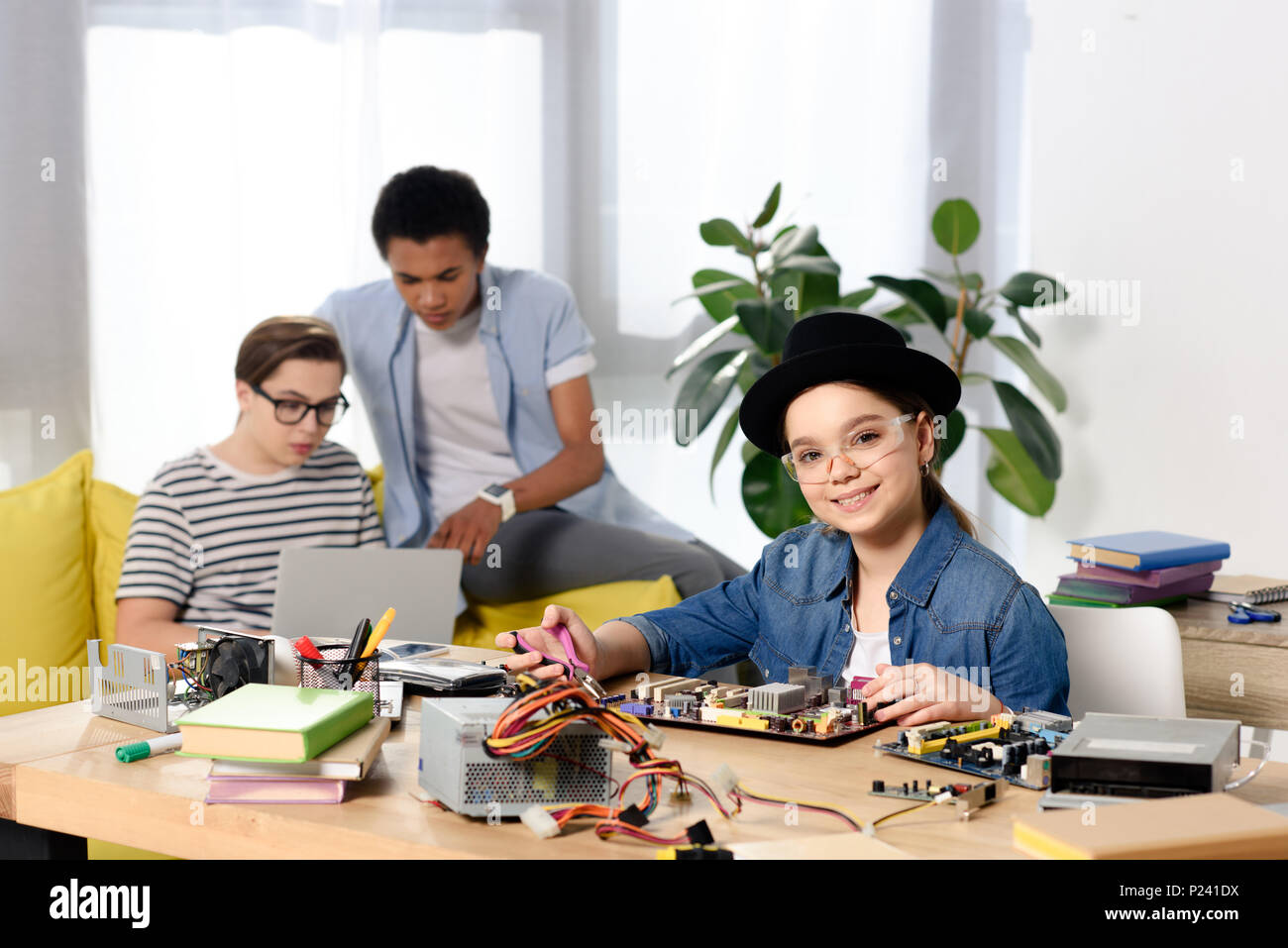 multicultural teen boys using laptop and female kid fixing computer ...