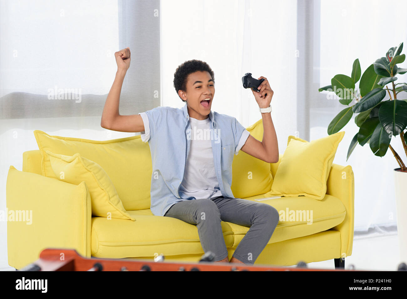 happy african american teenager winning video game and showing yes ...