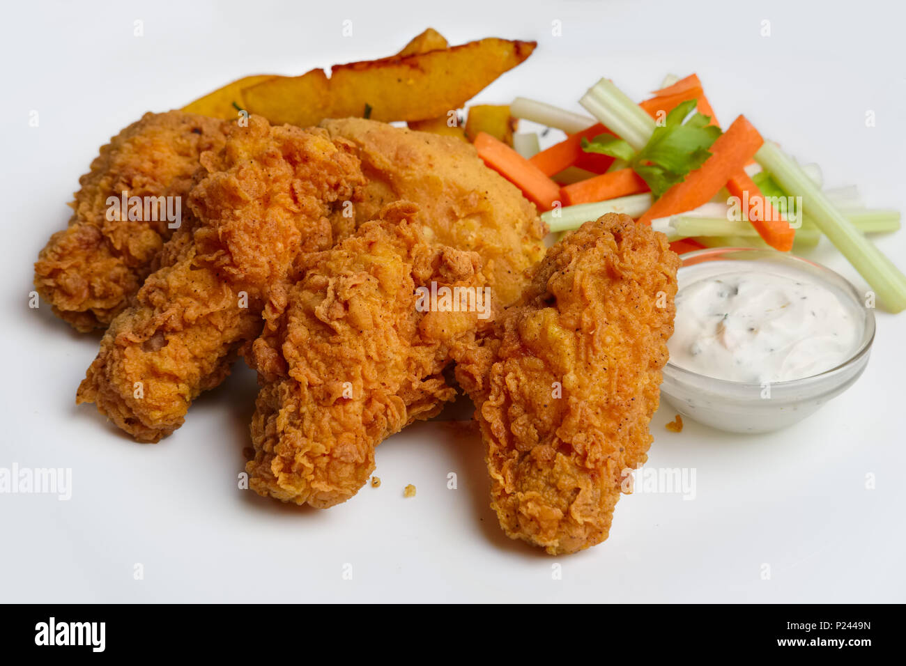 Buffalo chicken wings with fried potato and carrot and celery sticks ...