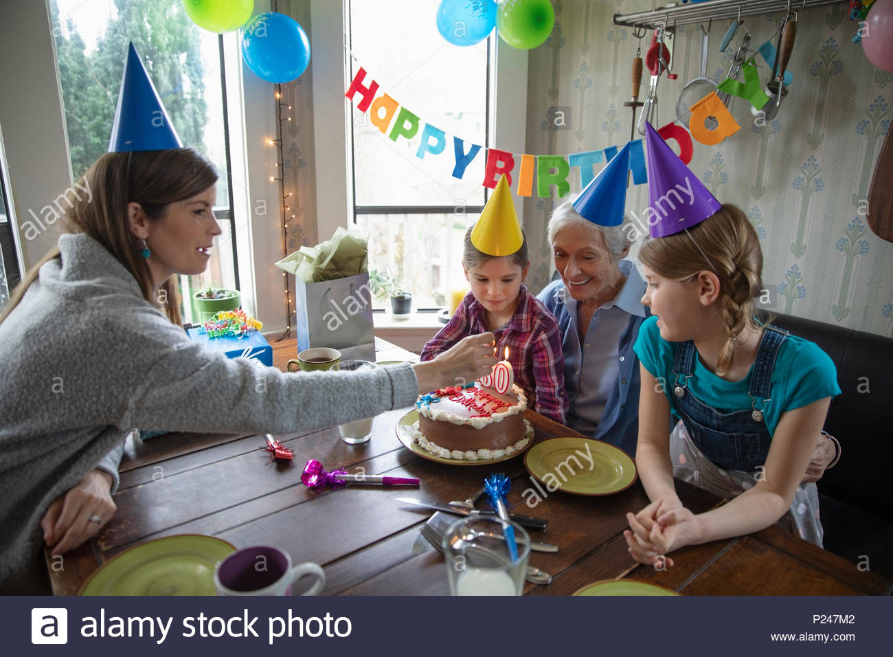 Multi-generation women celebrating birthday with cake Stock Photo - Alamy
