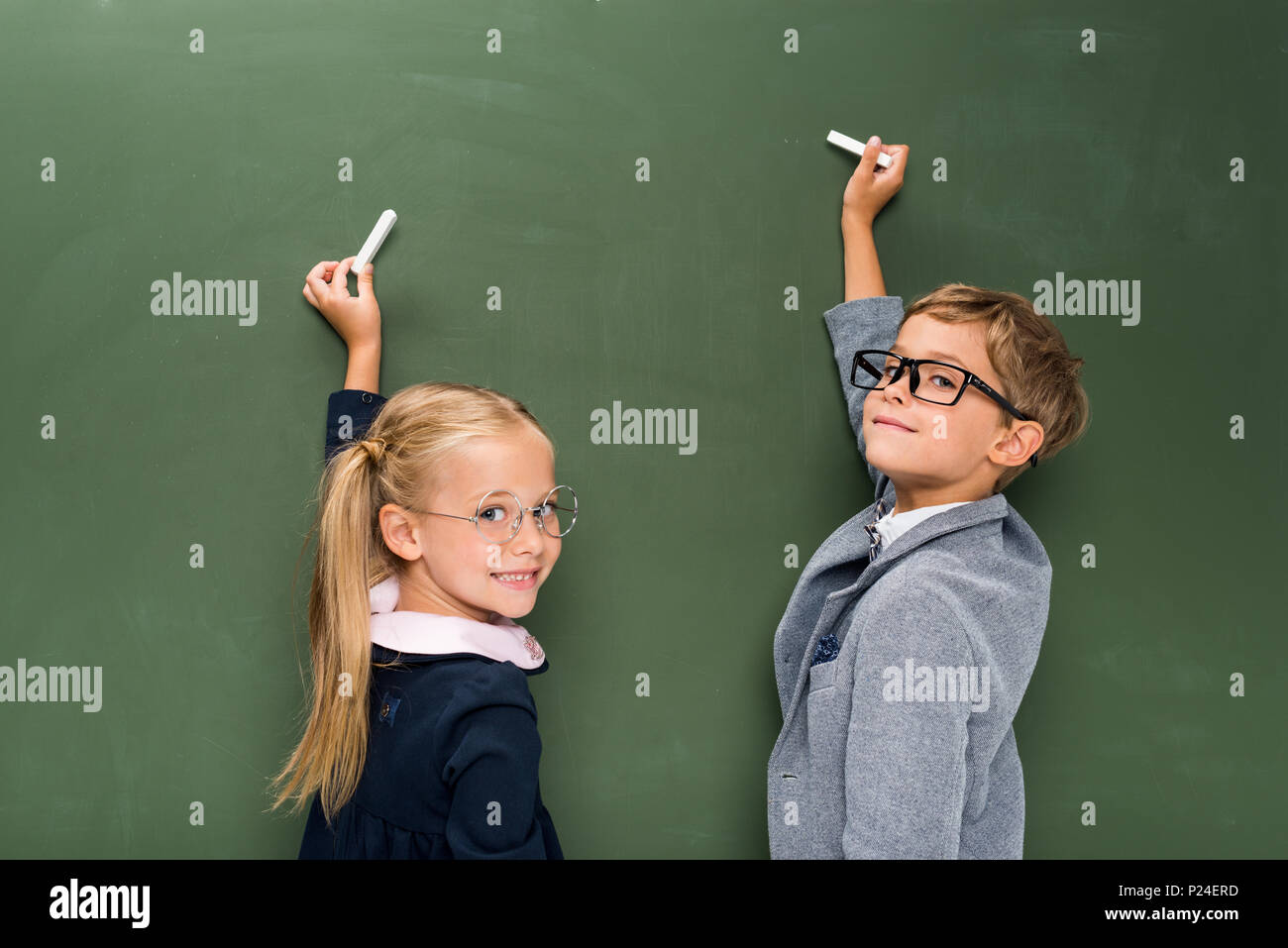 two beautiful happy pupils writing on chalkboard Stock Photo - Alamy
