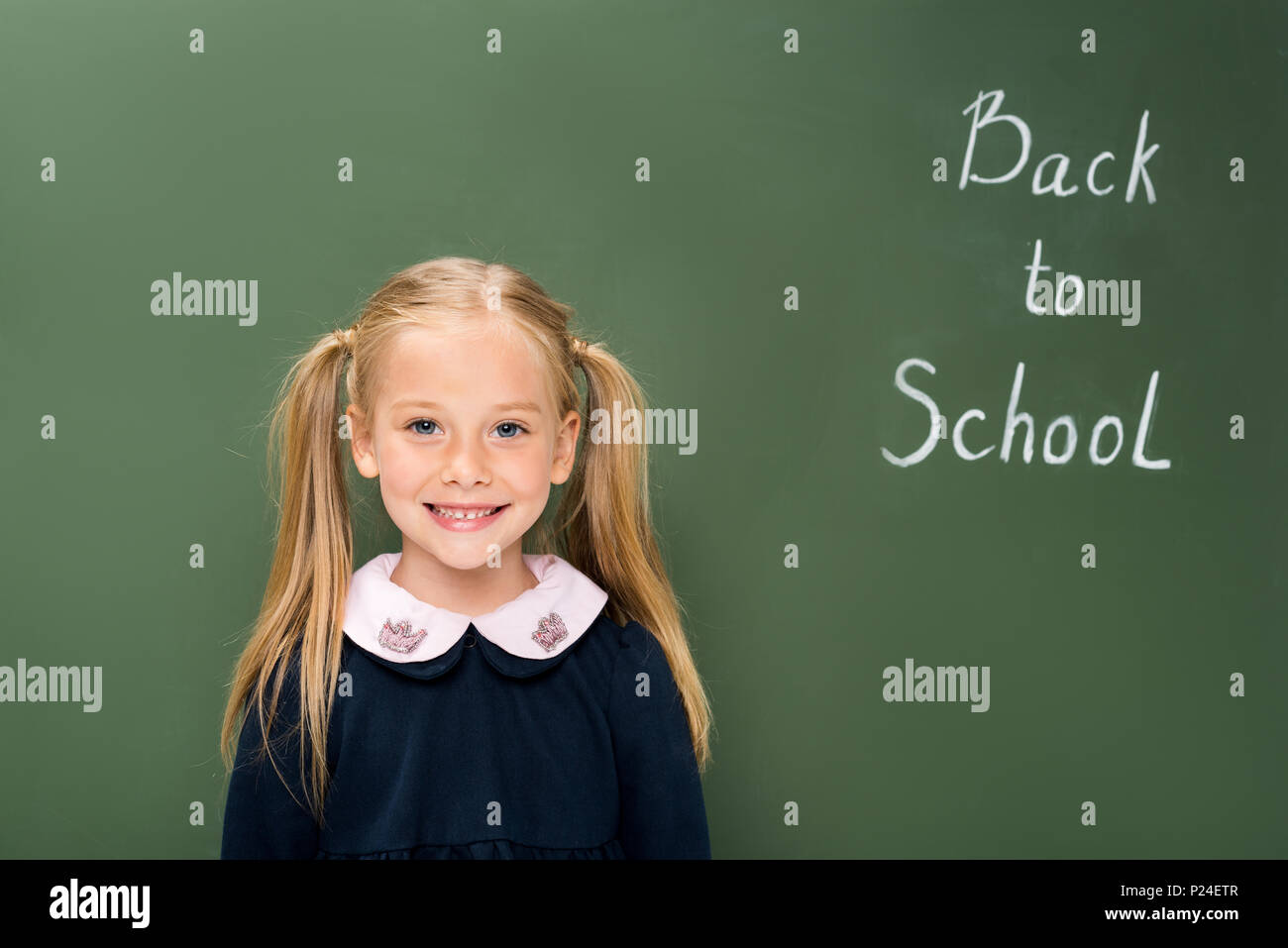 happy schoolgirl next to chalkboard with back to school sign Stock ...