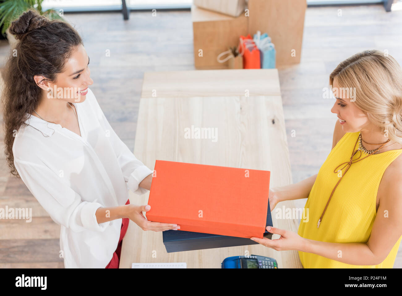 high angle view of cashier giving shoe boxes to woman Stock Photo - Alamy