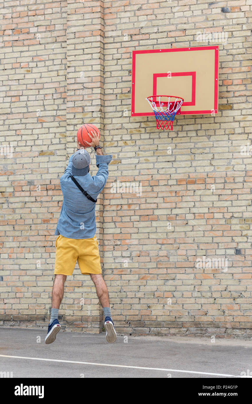 back view of young man playing basketball alone Stock Photo - Alamy