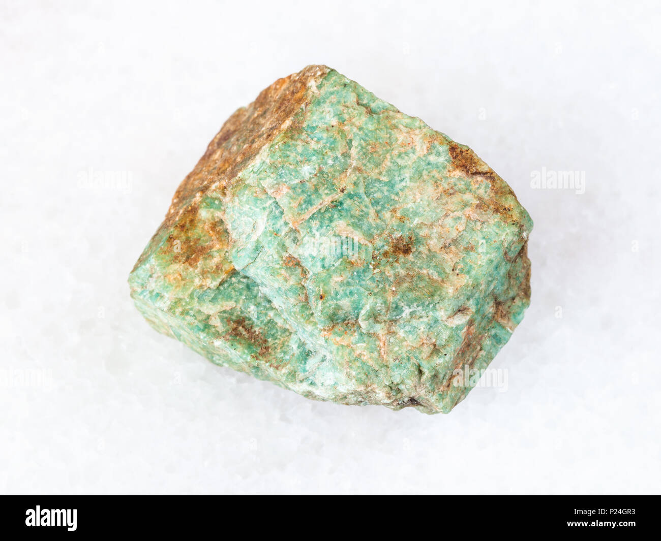 macro shooting of natural mineral - raw Amazonite stone on white marble ...