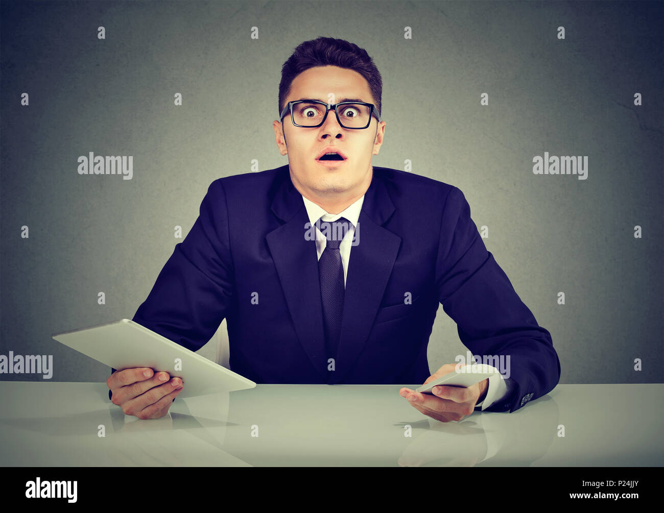 Busy confused employee with smartphone and tablet computer Stock Photo ...